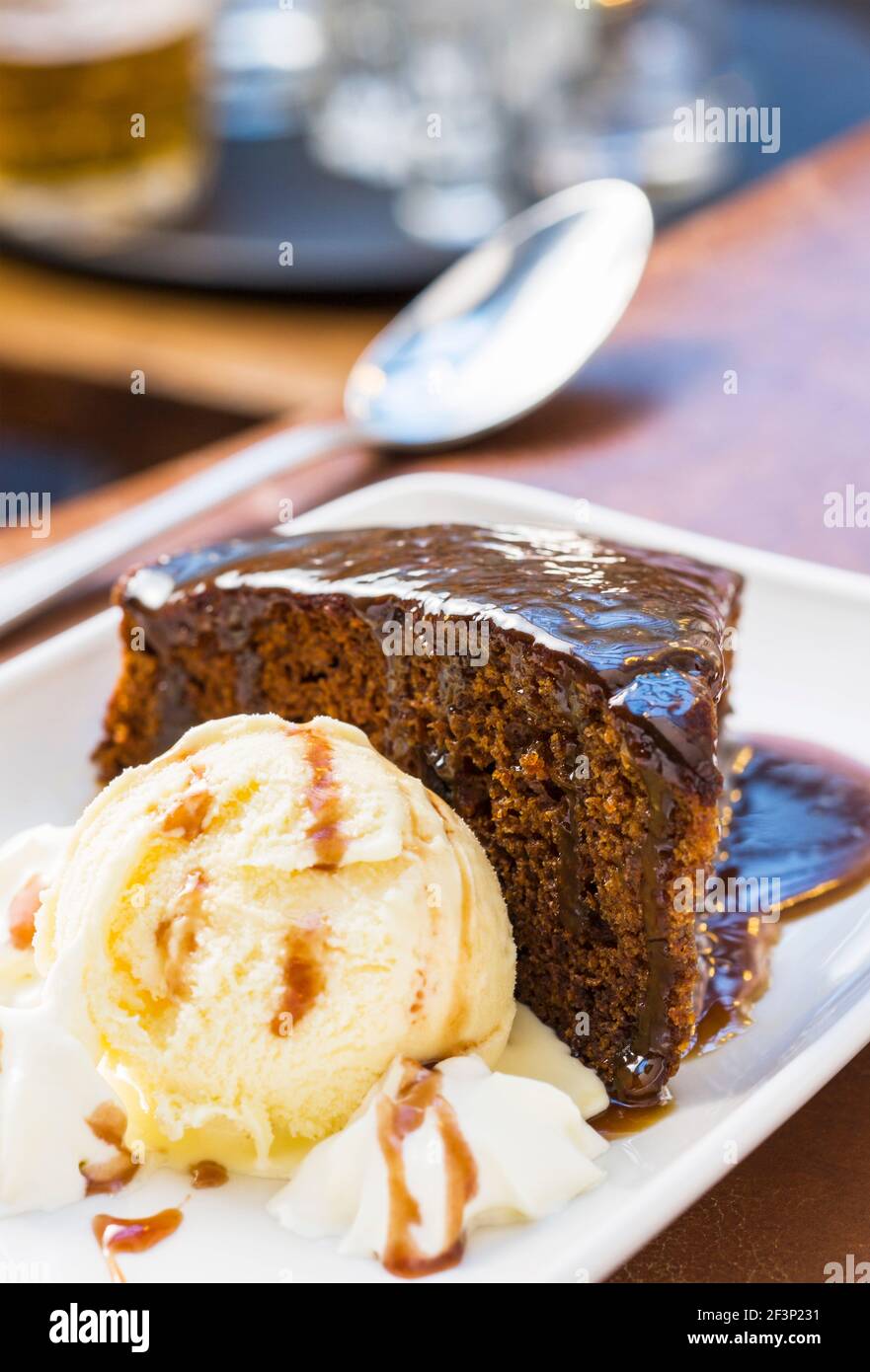 Slice of sticky toffee pudding with ice cream Stock Photo - Alamy