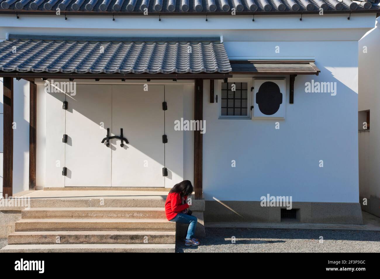 An exterior view shows the kawara ceramic tile roof and white plaster ...