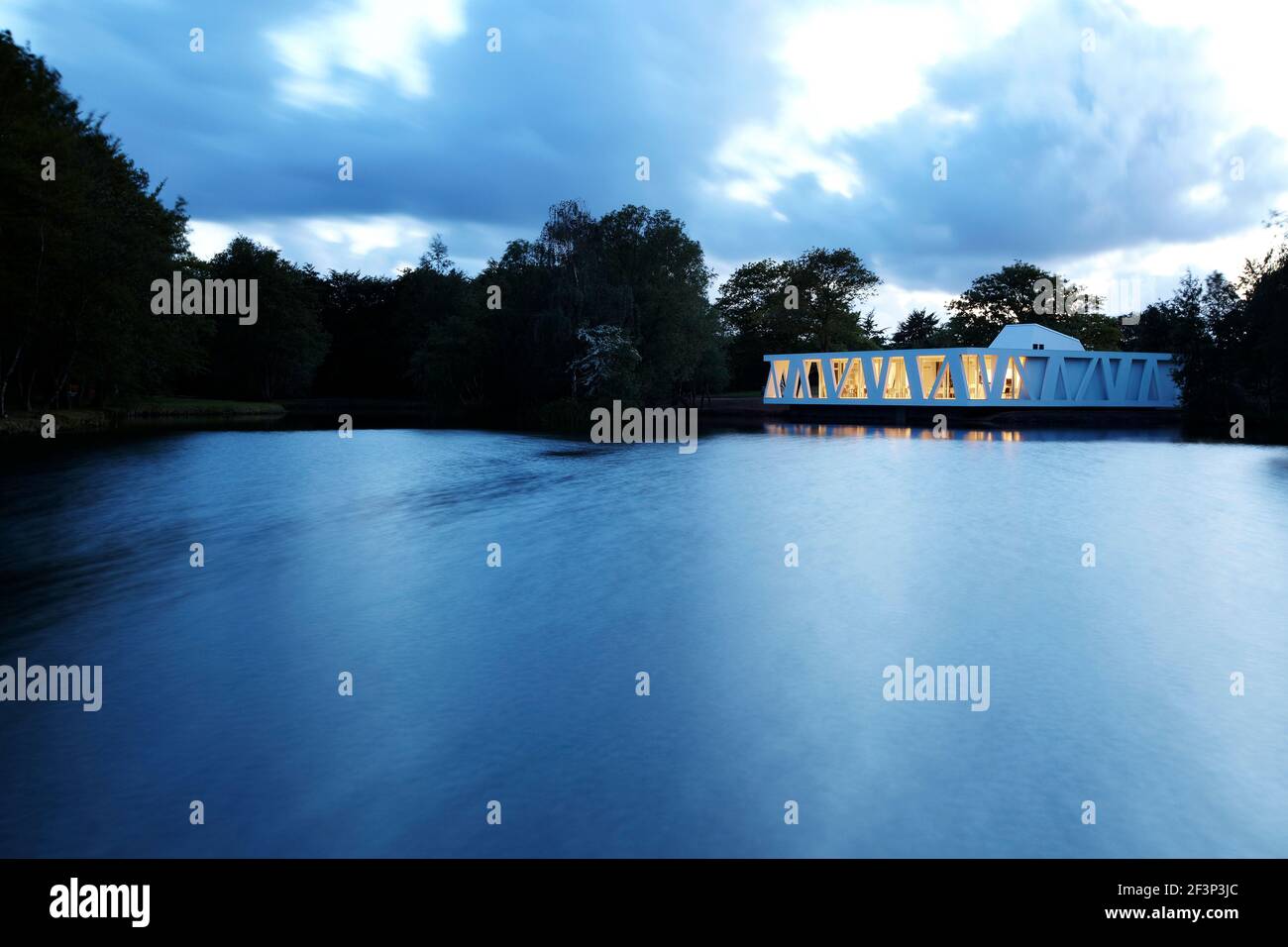 Art Pavilion, Videbaek, a popup building by a lake, lit up at night ...