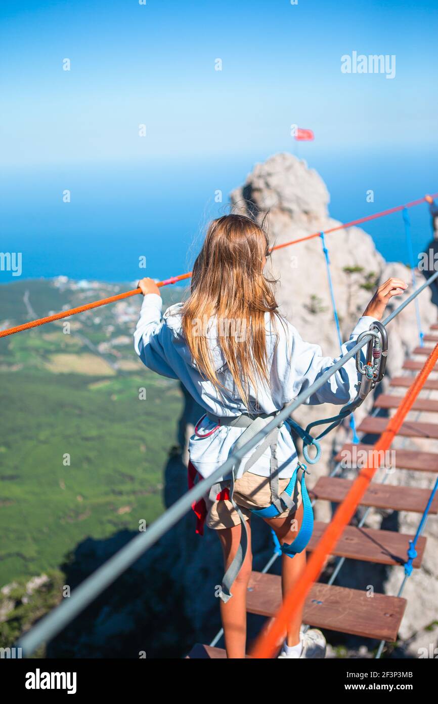 Girls crossing the chasm on the rope bridge Stock Photo - Alamy