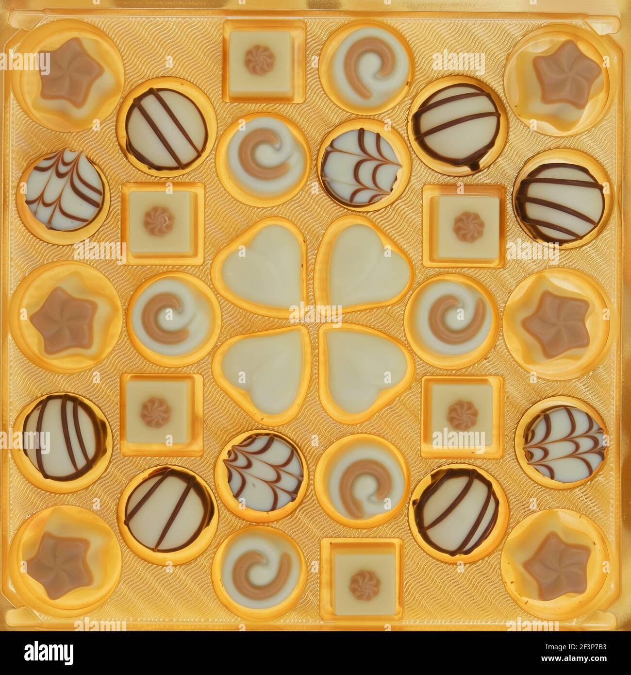 Chocolate candy .White chocolate. Assorted chocolate truffles in a gold ...
