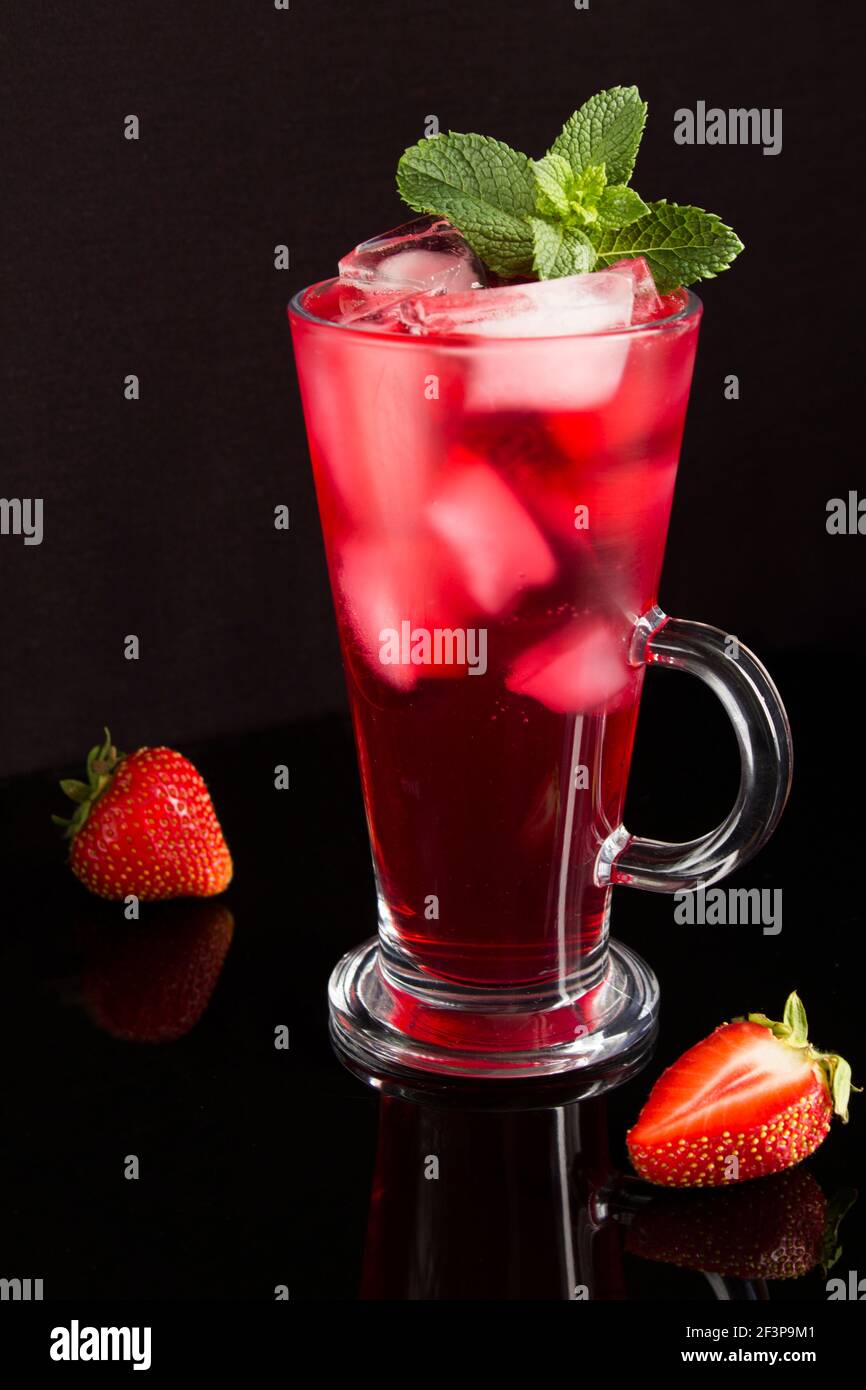 Strawberry lemonade with ice in the glass on the dark background ...