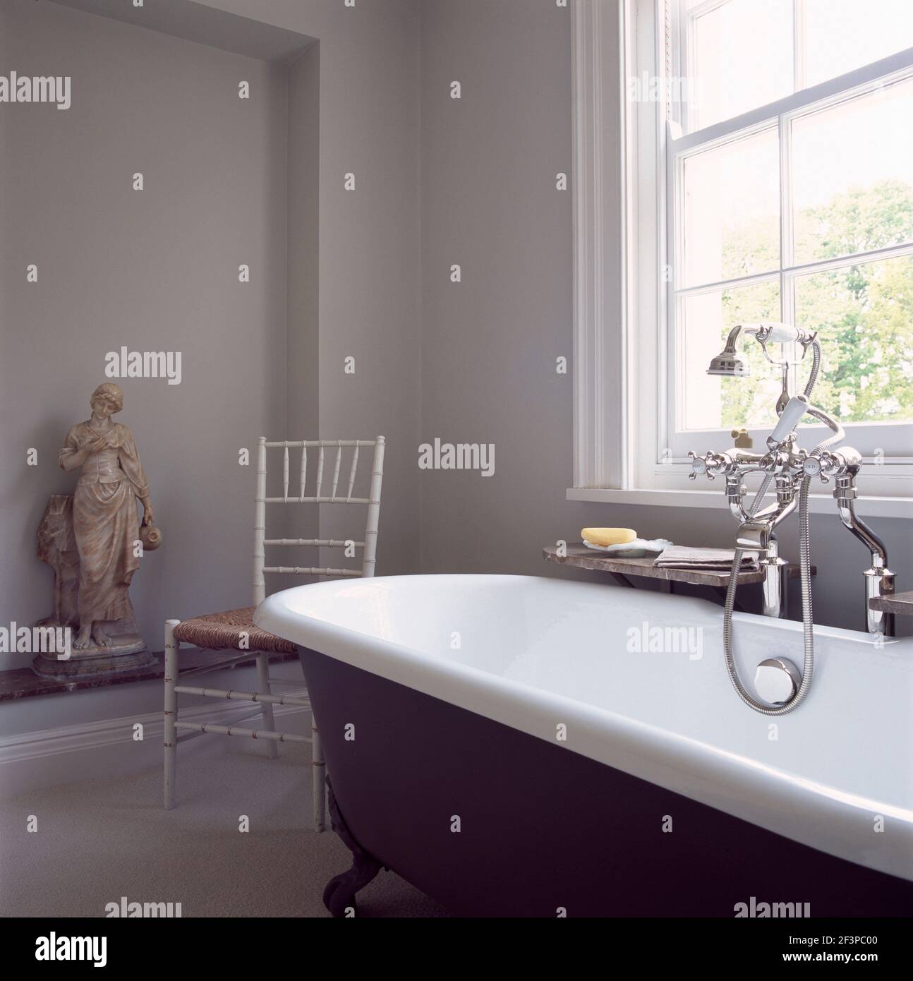 Wooden chair next to traditional style freestanding bathtub, Architects ...