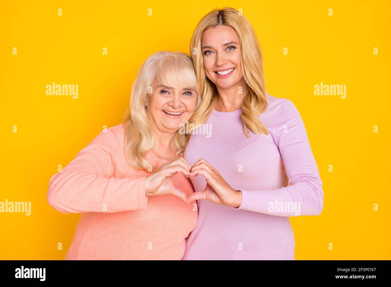 Photo of nice optimistic two woman grandmom daughter hug show heart ...