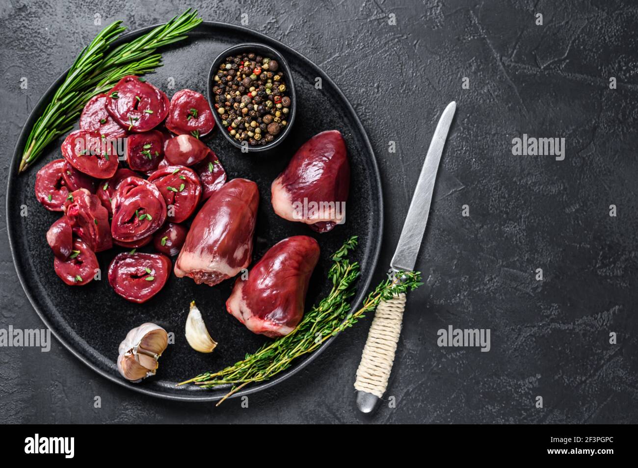 Sliced Raw turkey hearts ready for cooking. Black background. Top view ...