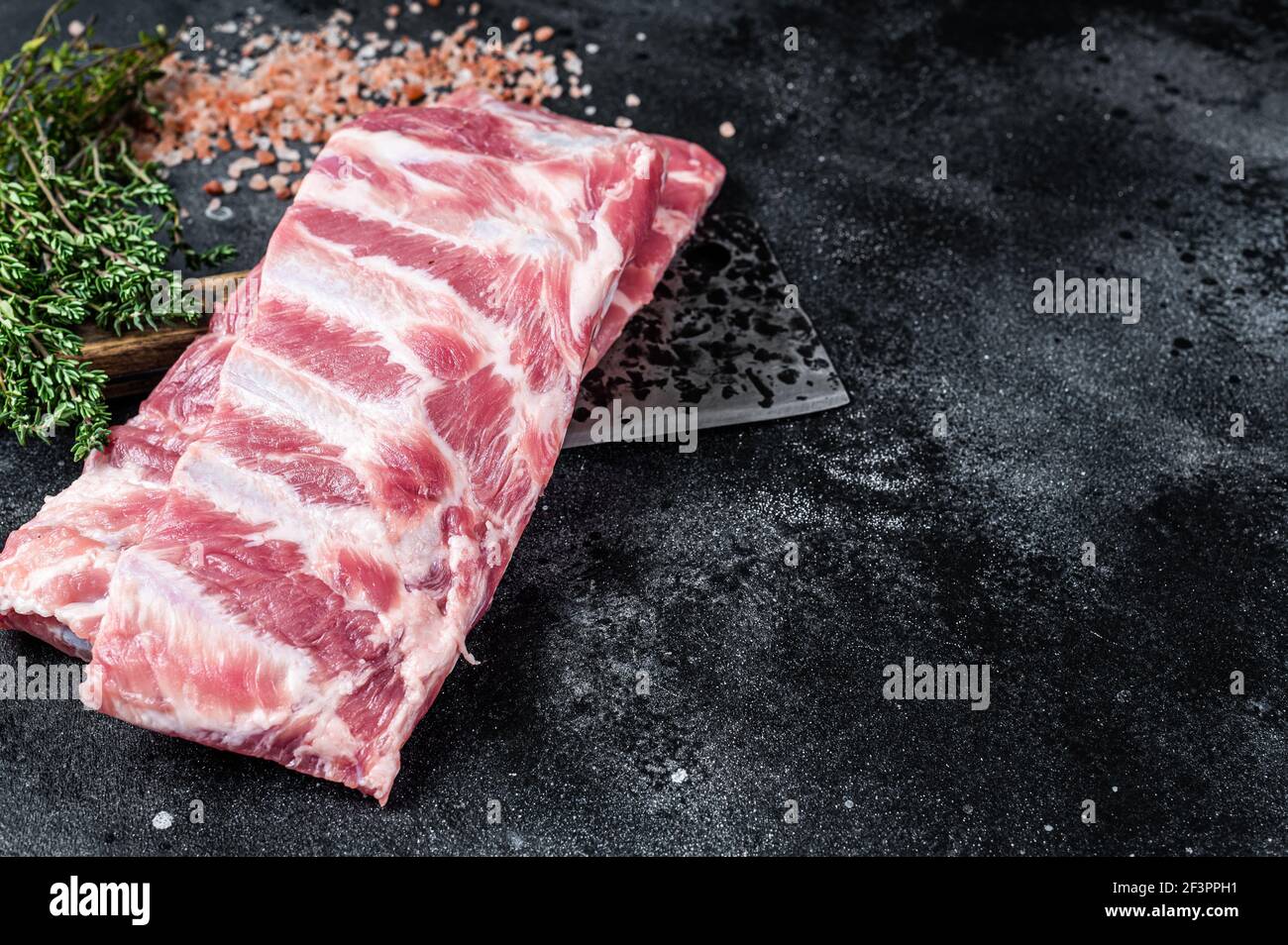 Uncooked Raw pork spare ribs on butcher meat cleaver. Black background ...
