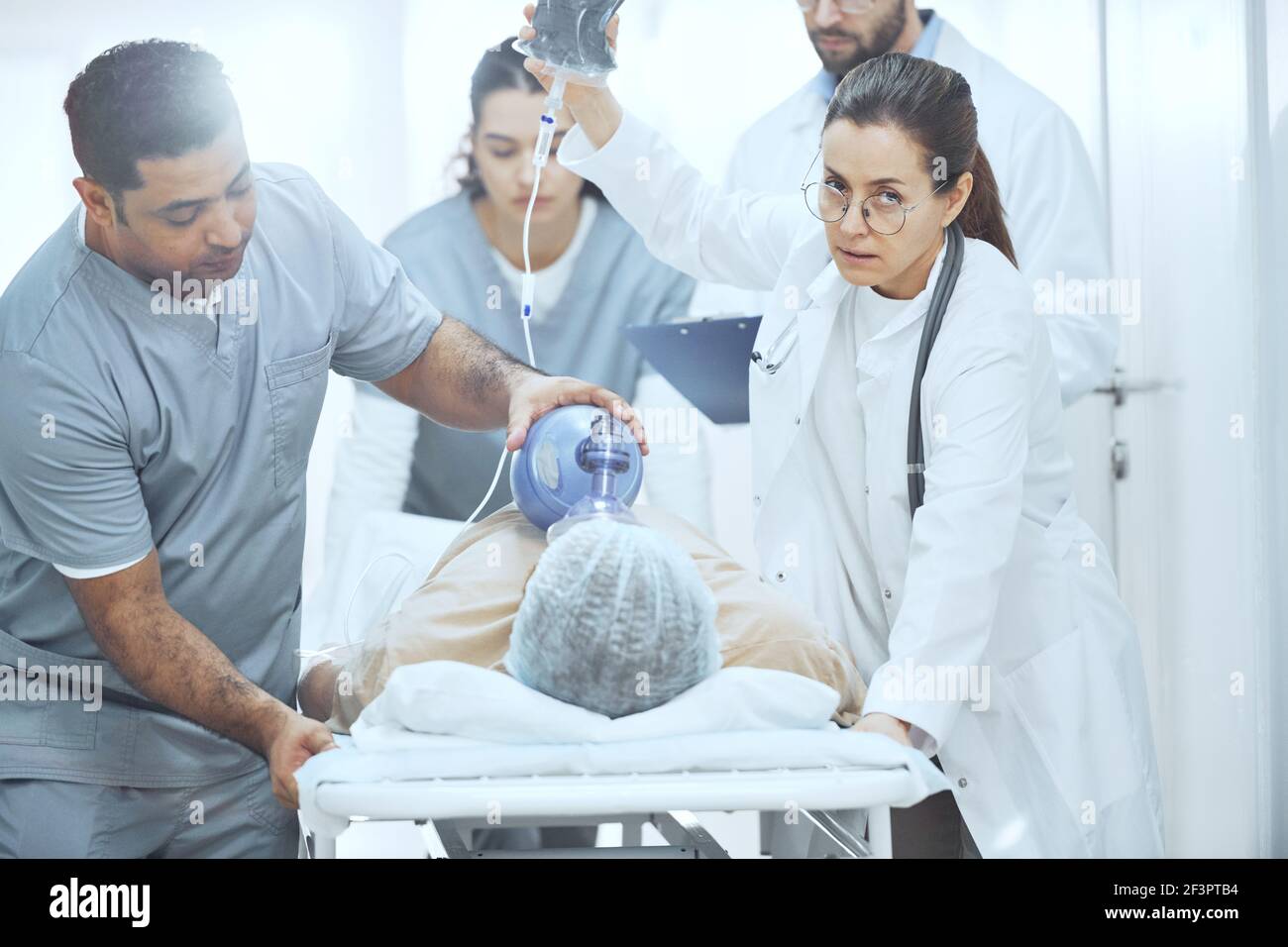 Patient lying with oxygen mask while doctors performing a reanimation ...
