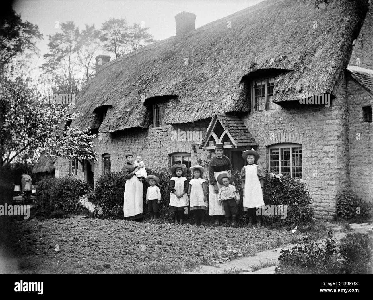 A thatched cottage, Marsh Gibbon, Buckinghamshire. A group of people ...