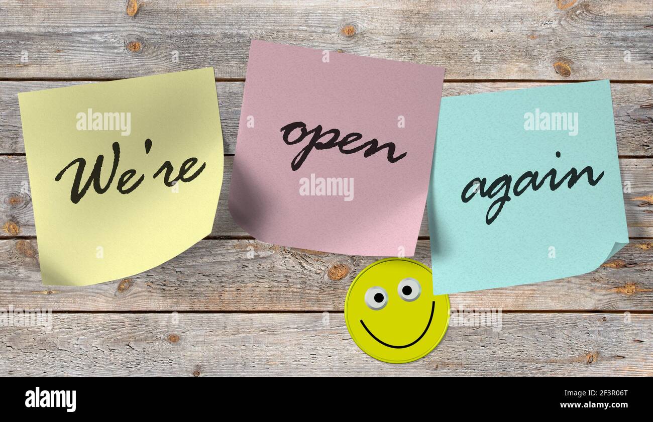 Sticky notes with the text "We're open again" on a wooden wall Stock ...