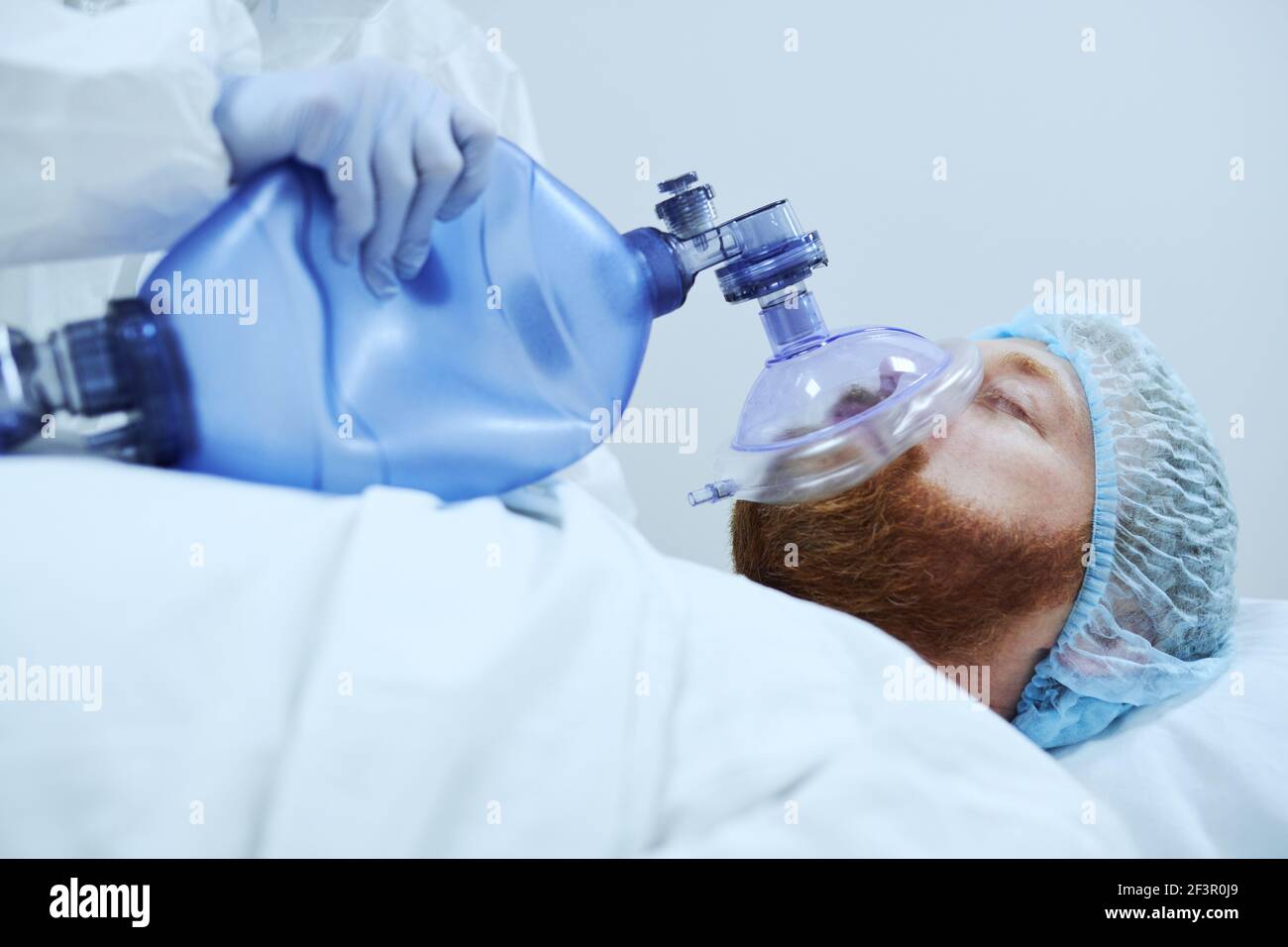 Male patient in oxygen mask breathing with defibrillator in operating ...