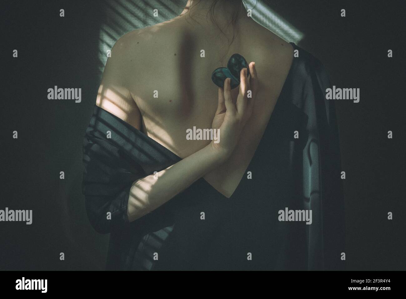 Back portrait of a woman with a v backless dress with the arm twisted ...