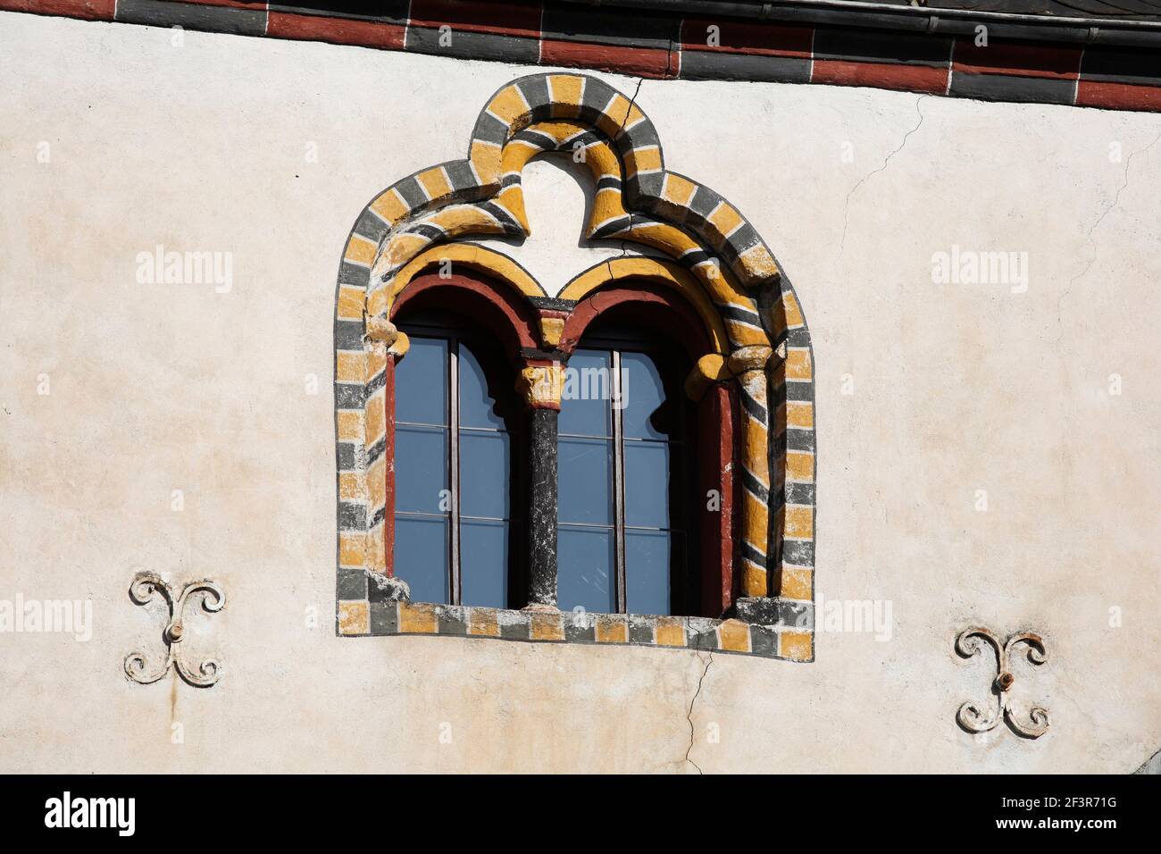 Detail of Romanesque style window with colorful frame in the residence ...