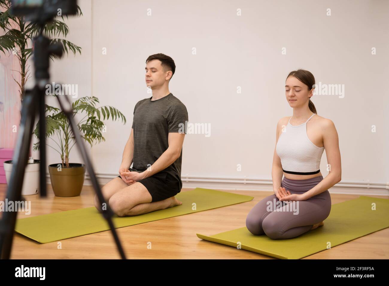 Yoga trainer teaching online training program in home studio behind ...
