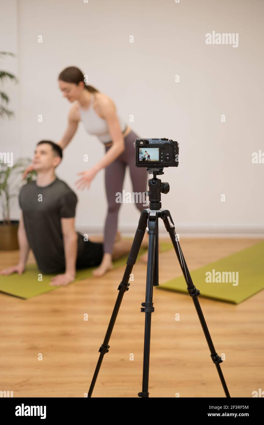Yoga trainer teaching online training program in home studio behind ...