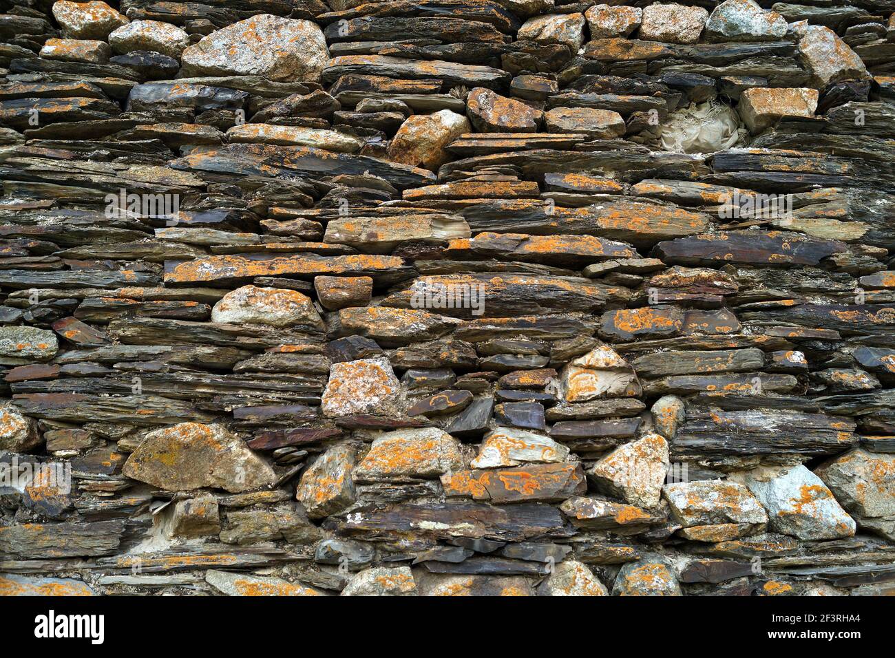 Wet wall of traditional stone masonry in an alpine village in the ...