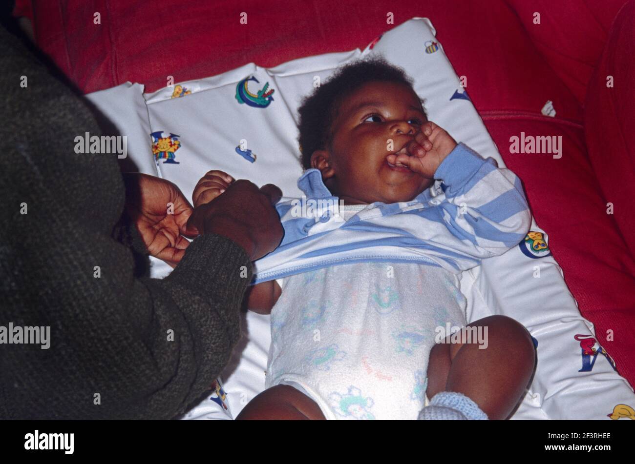 Mother Dressing Afro-Caribbean baby England Stock Photo - Alamy