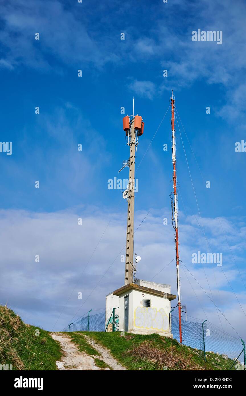 Two towers of communications with antennas against deep blue sky and white clouds Stock Photo ...