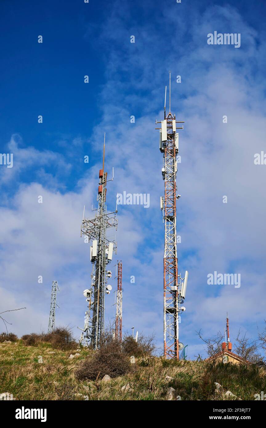 Two towers of communications with antennas against deep blue sky and white clouds Stock Photo ...