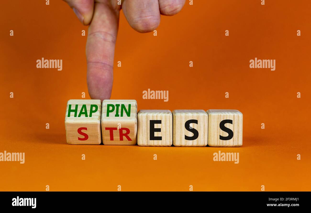Happiness instead of stress. Businessman turns a cube and changes the ...