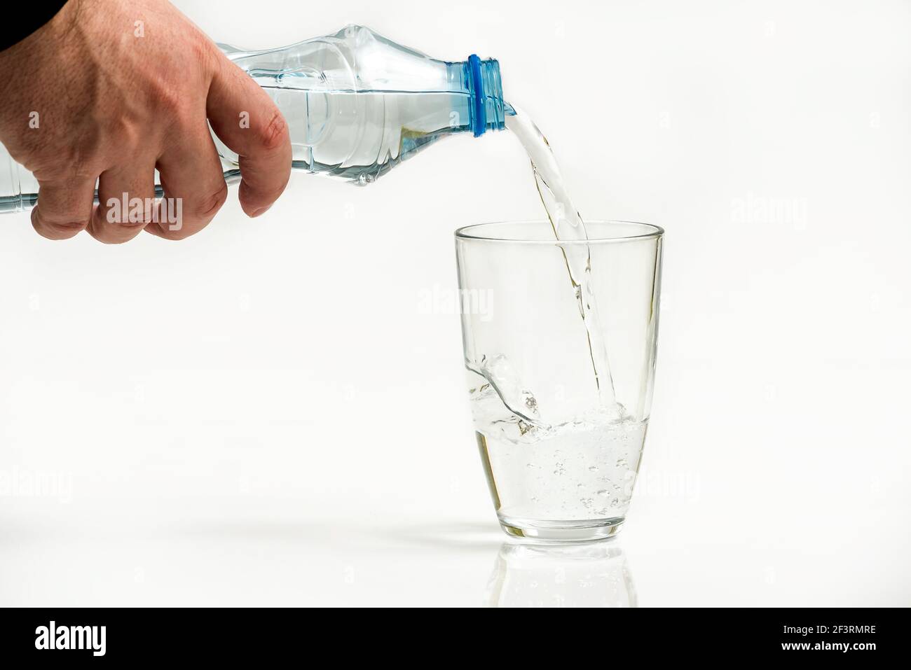 Water bottle pour water to glass on white background Stock Photo - Alamy