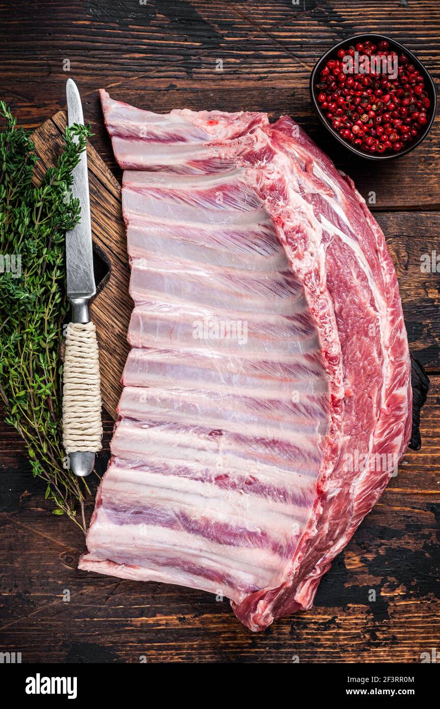 Mutton lamb ribs rack on wooden cutting board. Dark wooden background ...