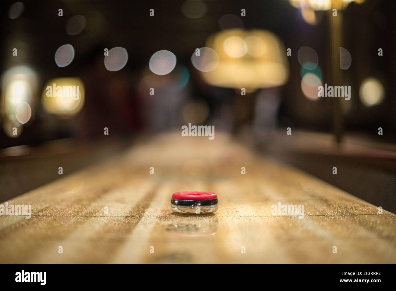 Red puck approaching the 3 point zone of a shuffleboard table Stock ...