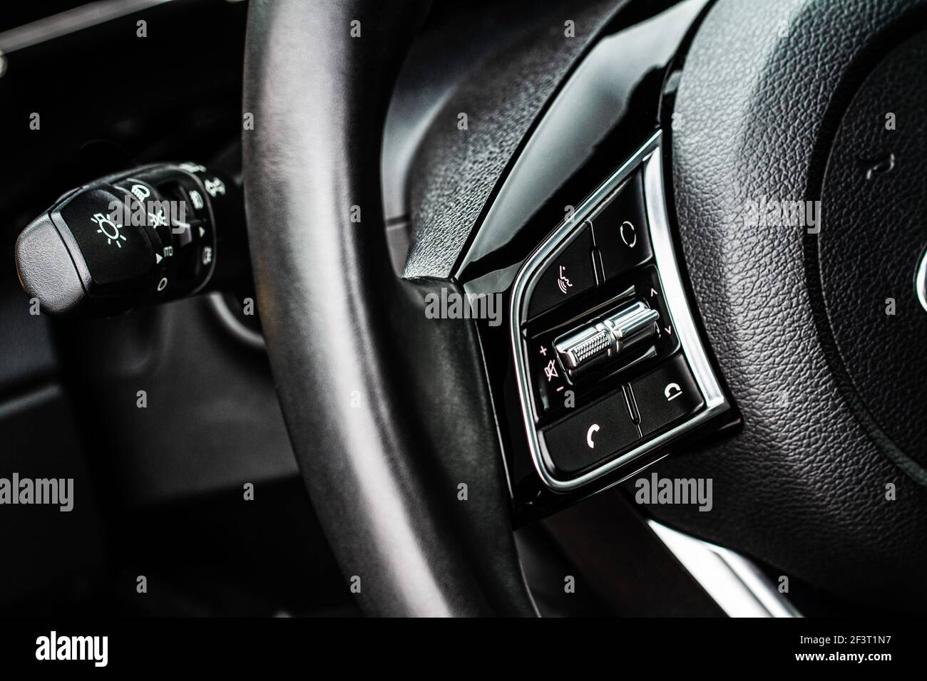 Vehicle interior of a modern car. Multiple buttons on the steering ...