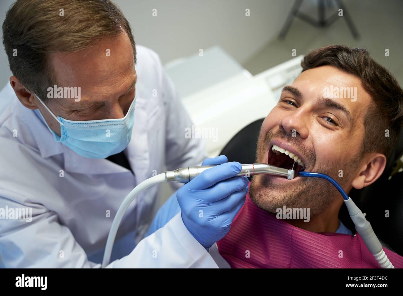 Smiley patient feeling good during his dental treatment Stock Photo - Alamy
