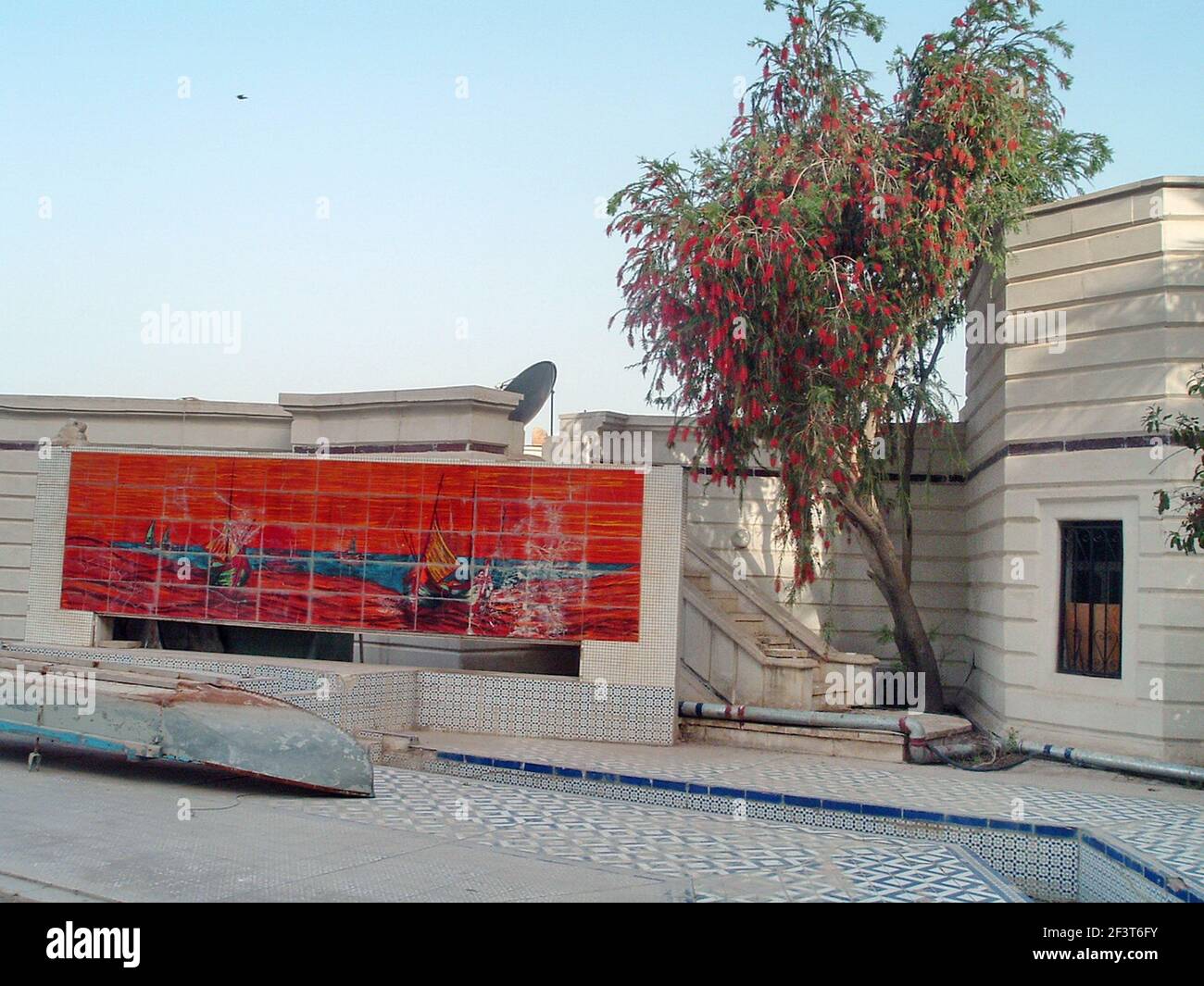 Bottle brush try by a mural on a Sadaam era building on Camp Slayer, in ...