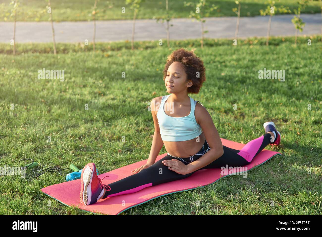 Sporty Afro American girl doing the splits in park Stock Photo - Alamy