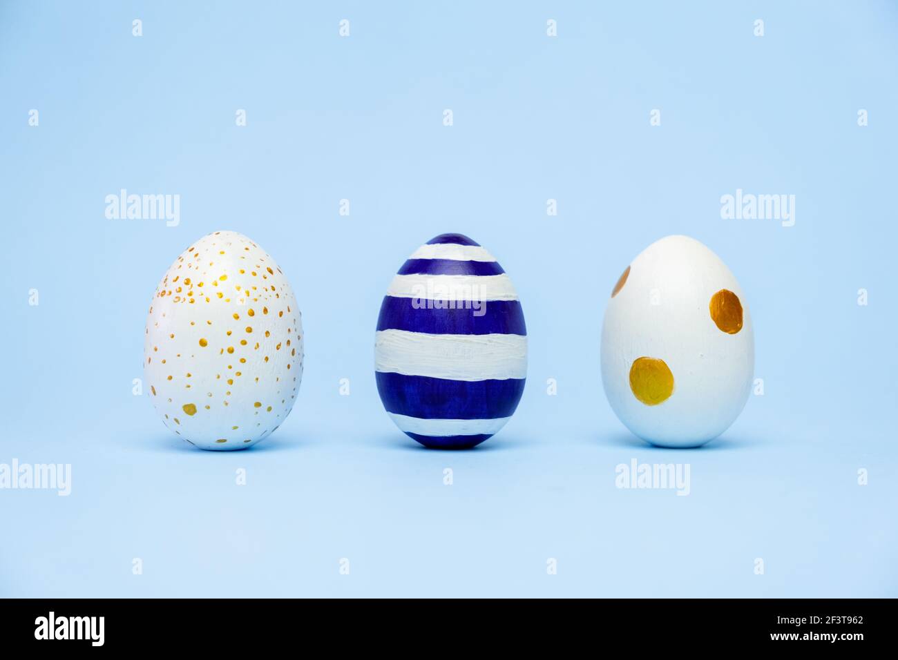 Three easter trendy colored classic blue and golden decorated eggs ...