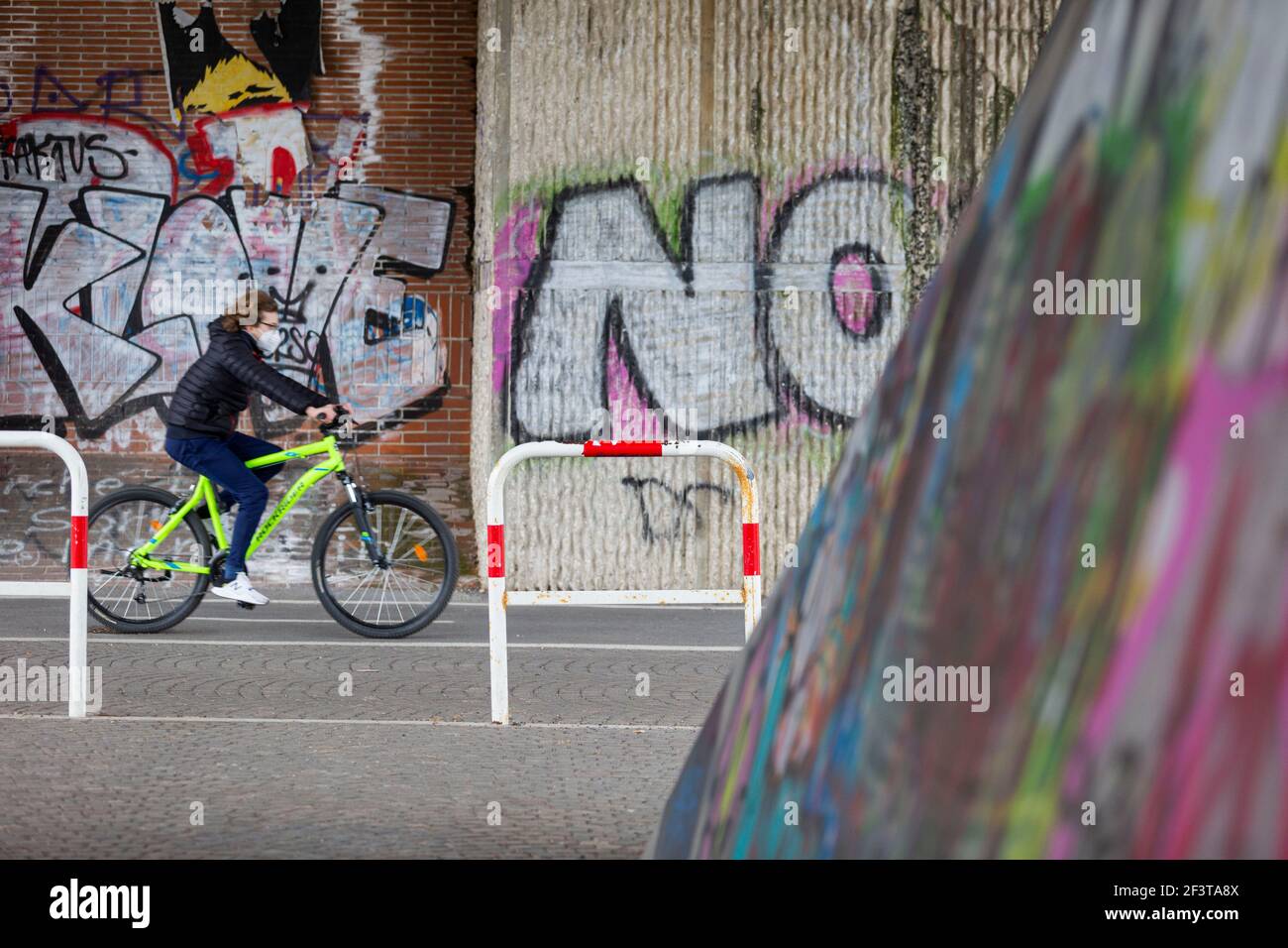 Cyclist riding past graffiti Stock Photo - Alamy
