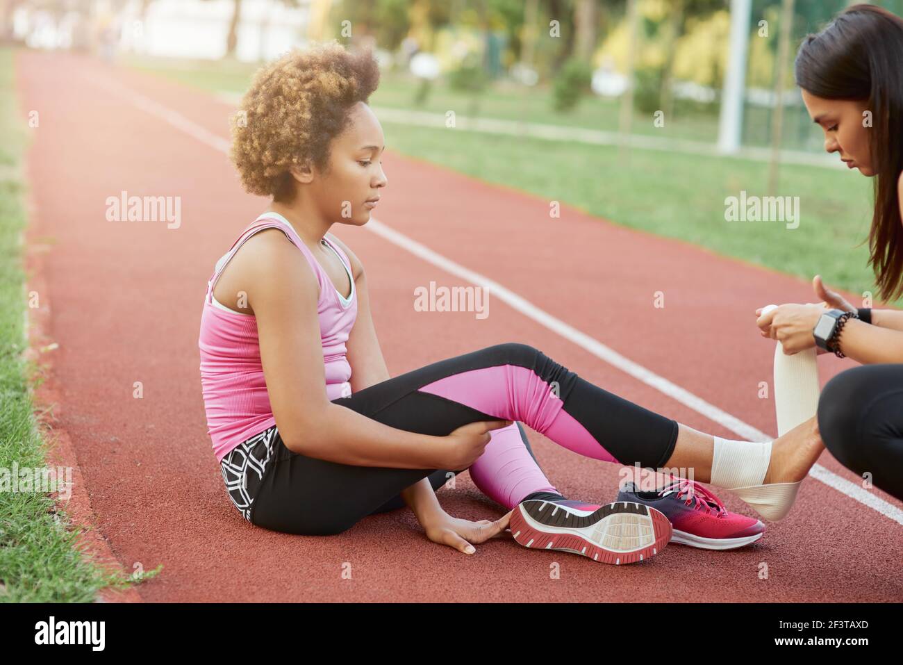 Young woman putting bandage on little girl injured leg Stock Photo - Alamy