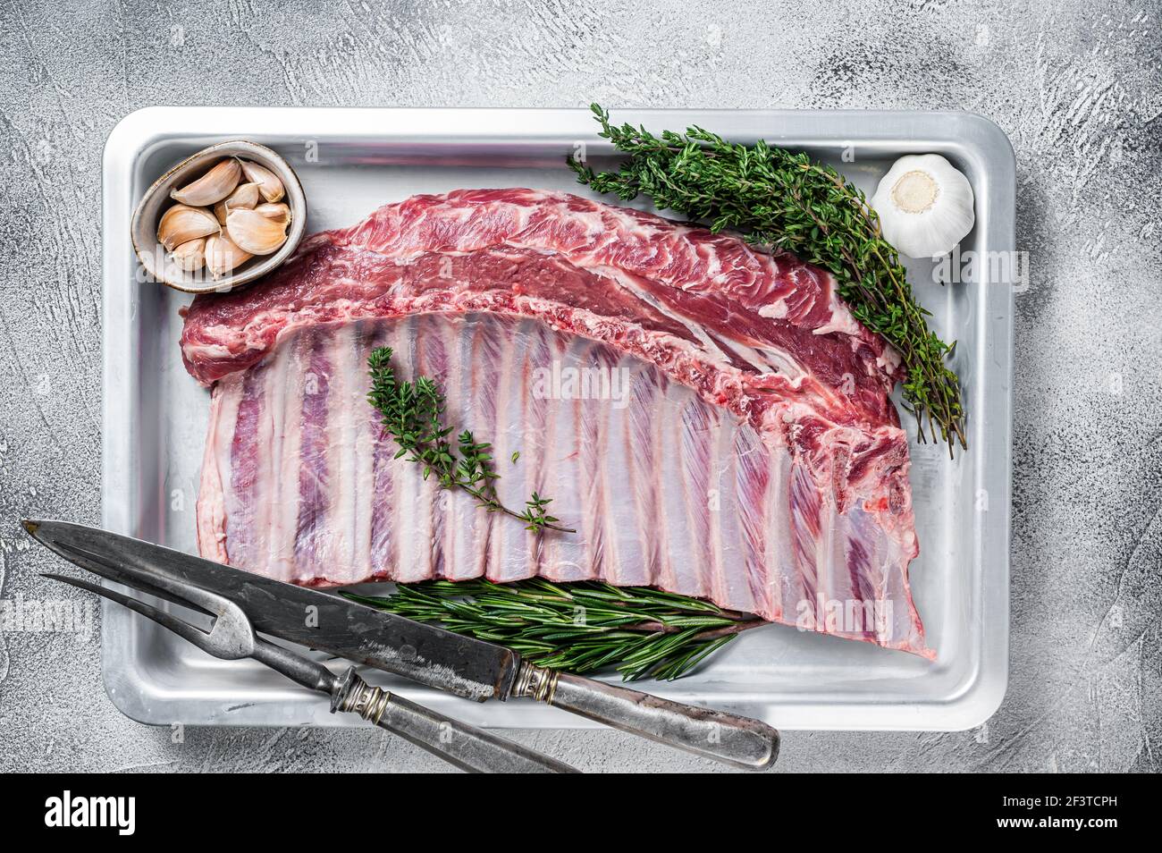 Raw uncooked rack of mutton lamb ribs in baking dish. White background ...