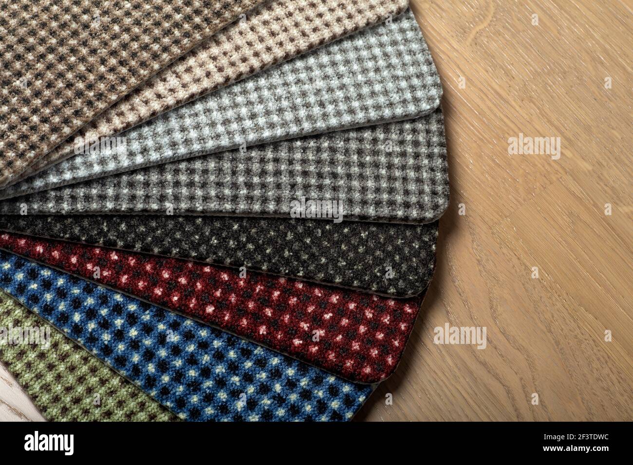 Types and samples of carpets in different colors on wooden floor ...