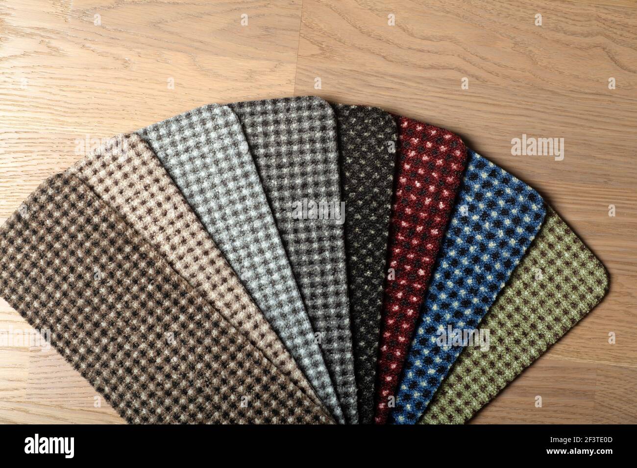Types and samples of carpets in different colors on wooden floor ...
