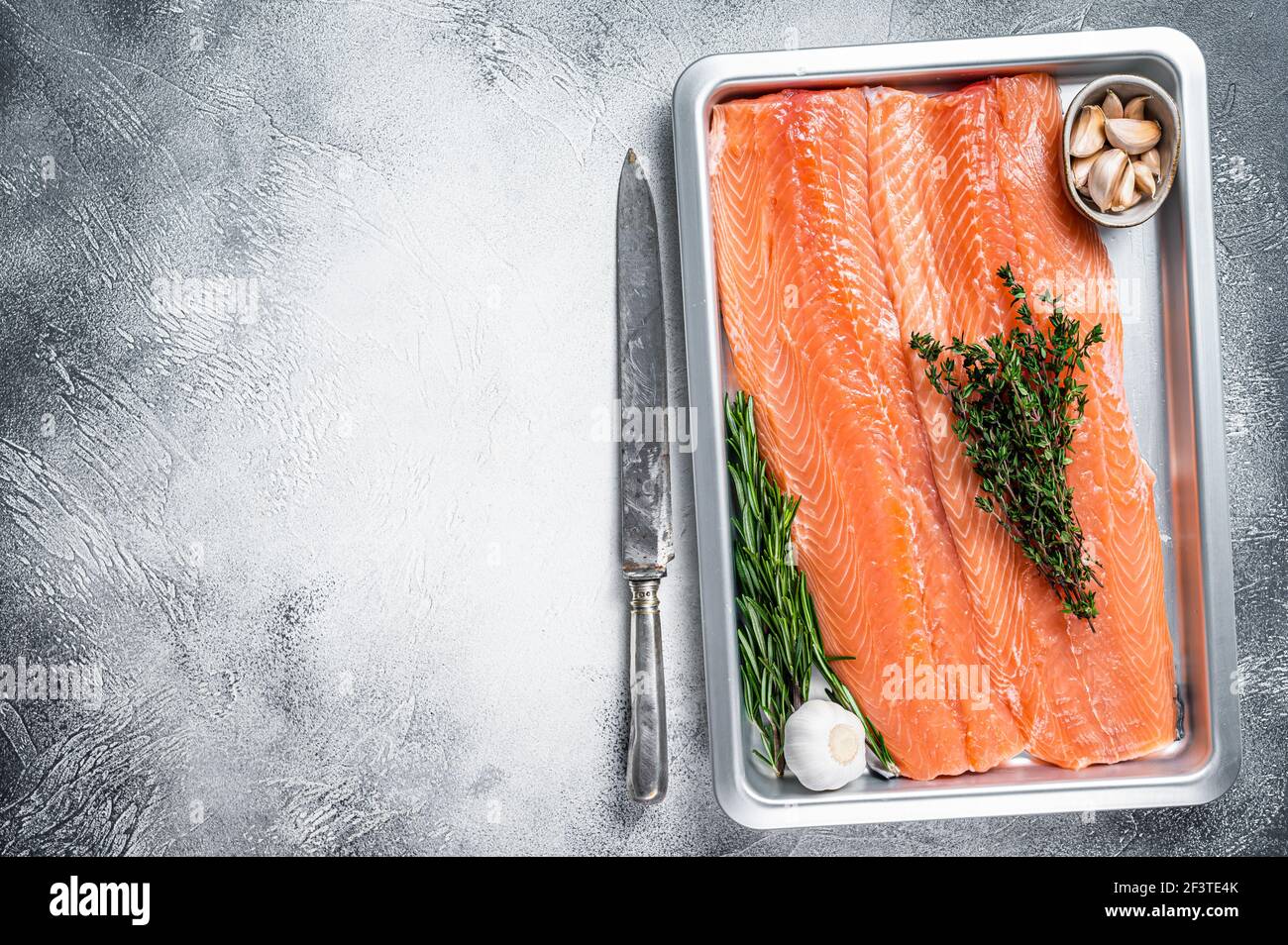Raw uncooked sea salmon fillet fish in a kitchen tray with herbs. White ...