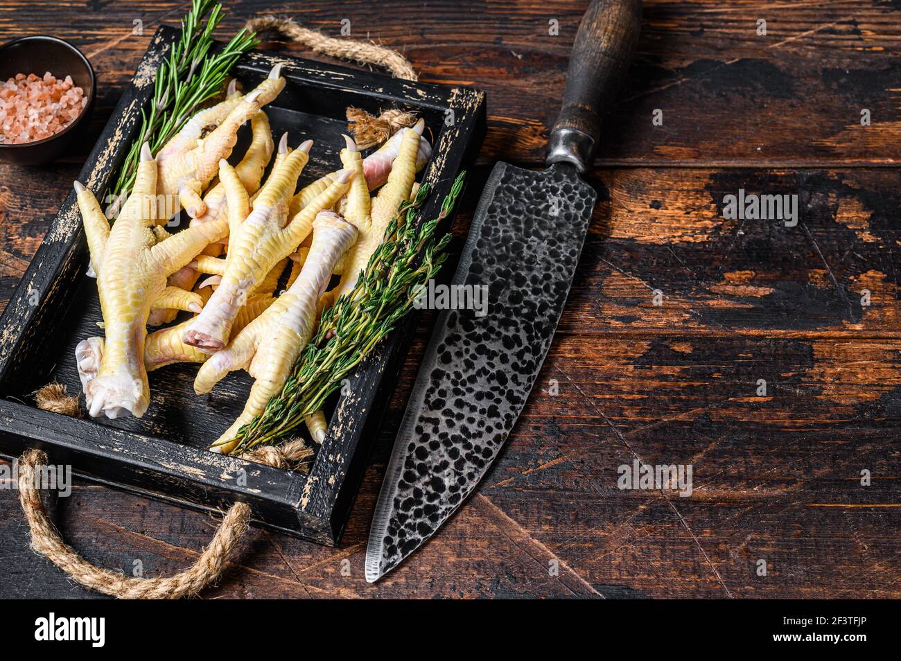 Raw Chicken paws feets on butcher chopping board with knife. Dark ...