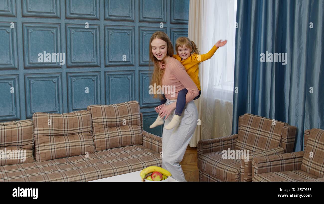 Happy family mother and child kid daughter dancing, playing piggyback ...