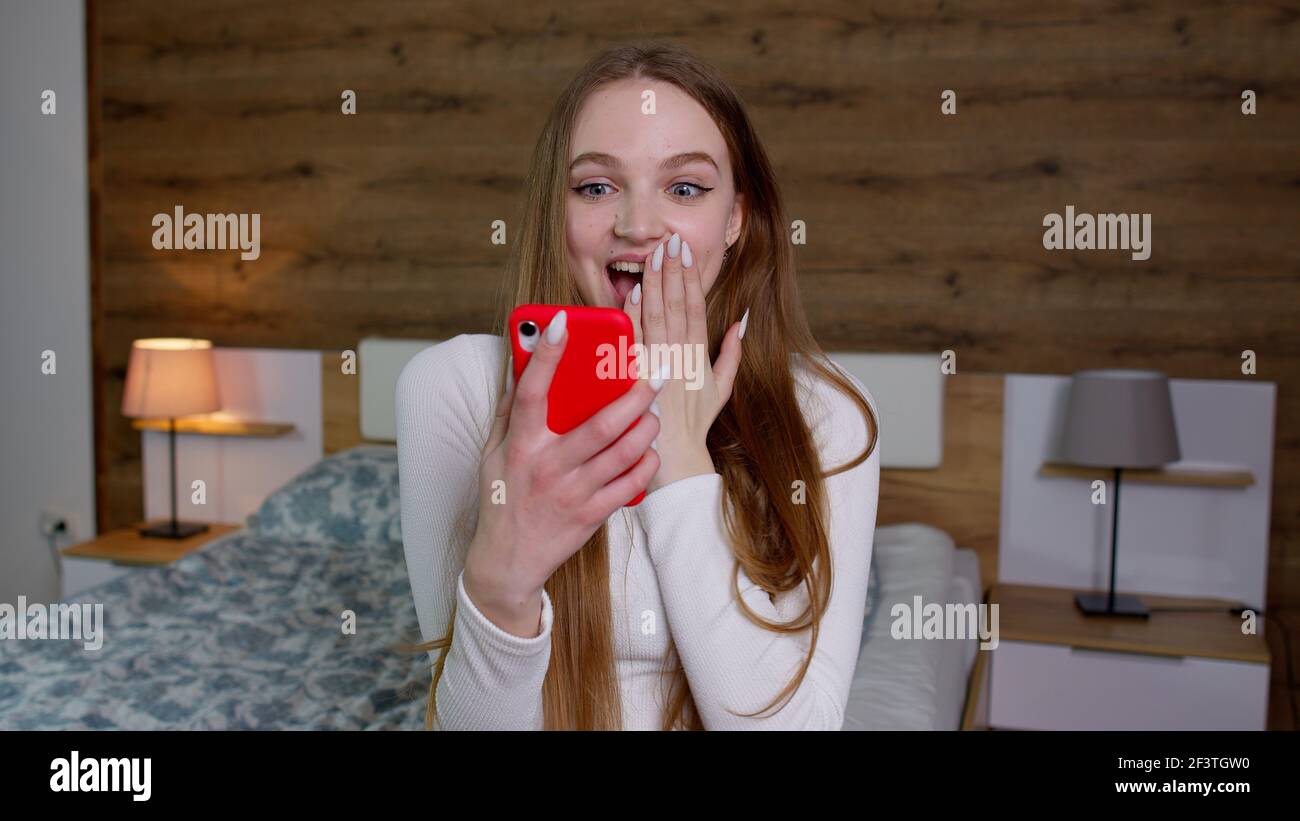 Surprised shocked woman holding mobile phone showing amazed wow like ...