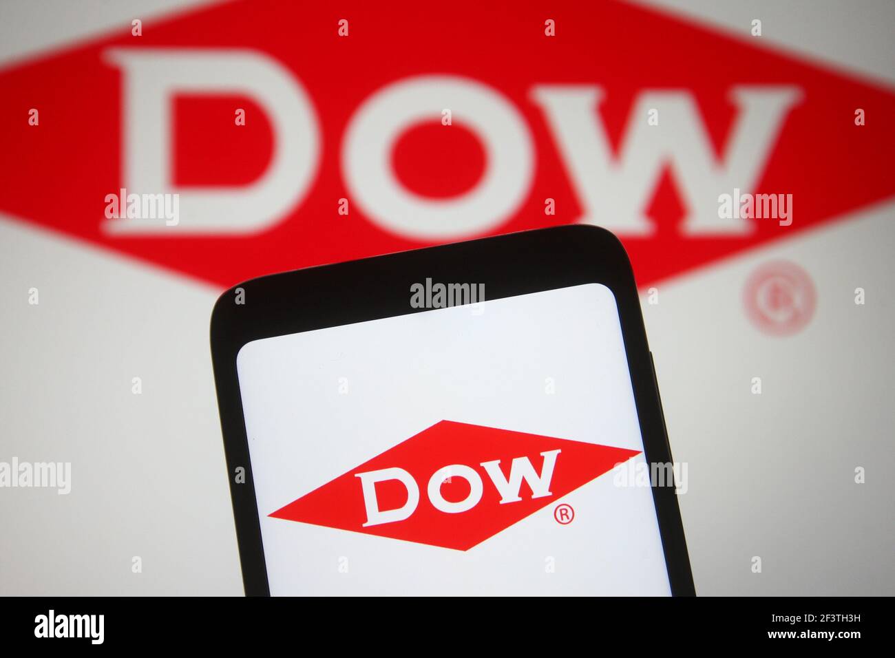 In this photo illustration a Dow logo is seen on a smartphone and a pc ...