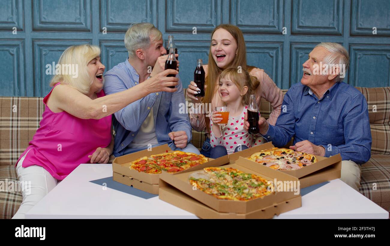 Happy multigenerational family having lunch party at home, eating pizza ...
