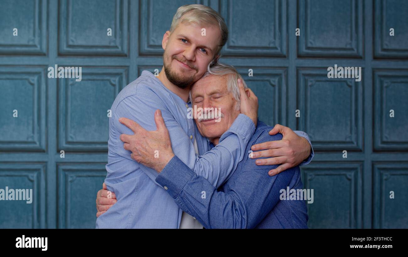 Happy excited young man embracing gray-haired old dad or grandfather ...