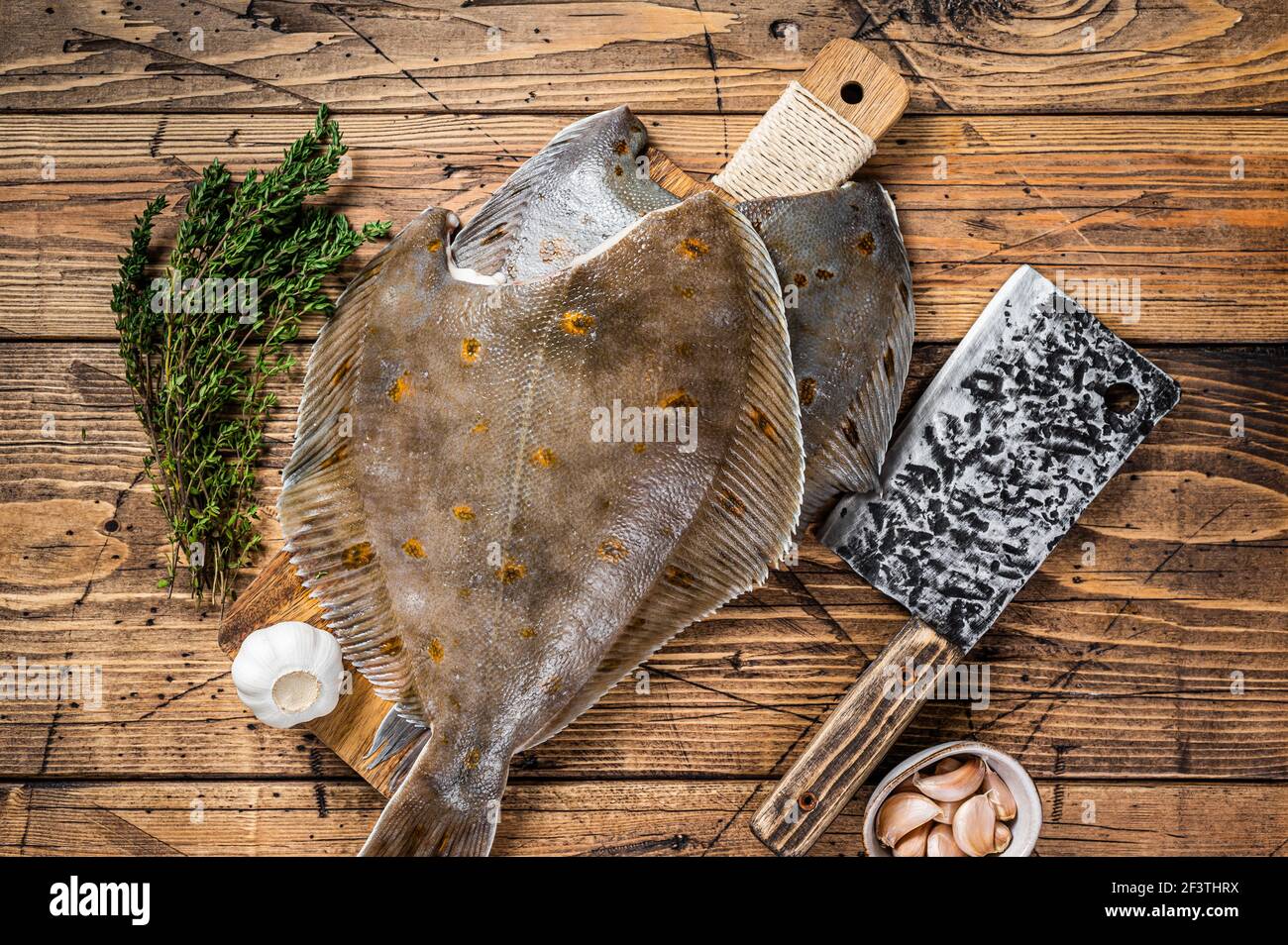 Raw flounder flatfish on butcher board with cleaver. wooden background ...