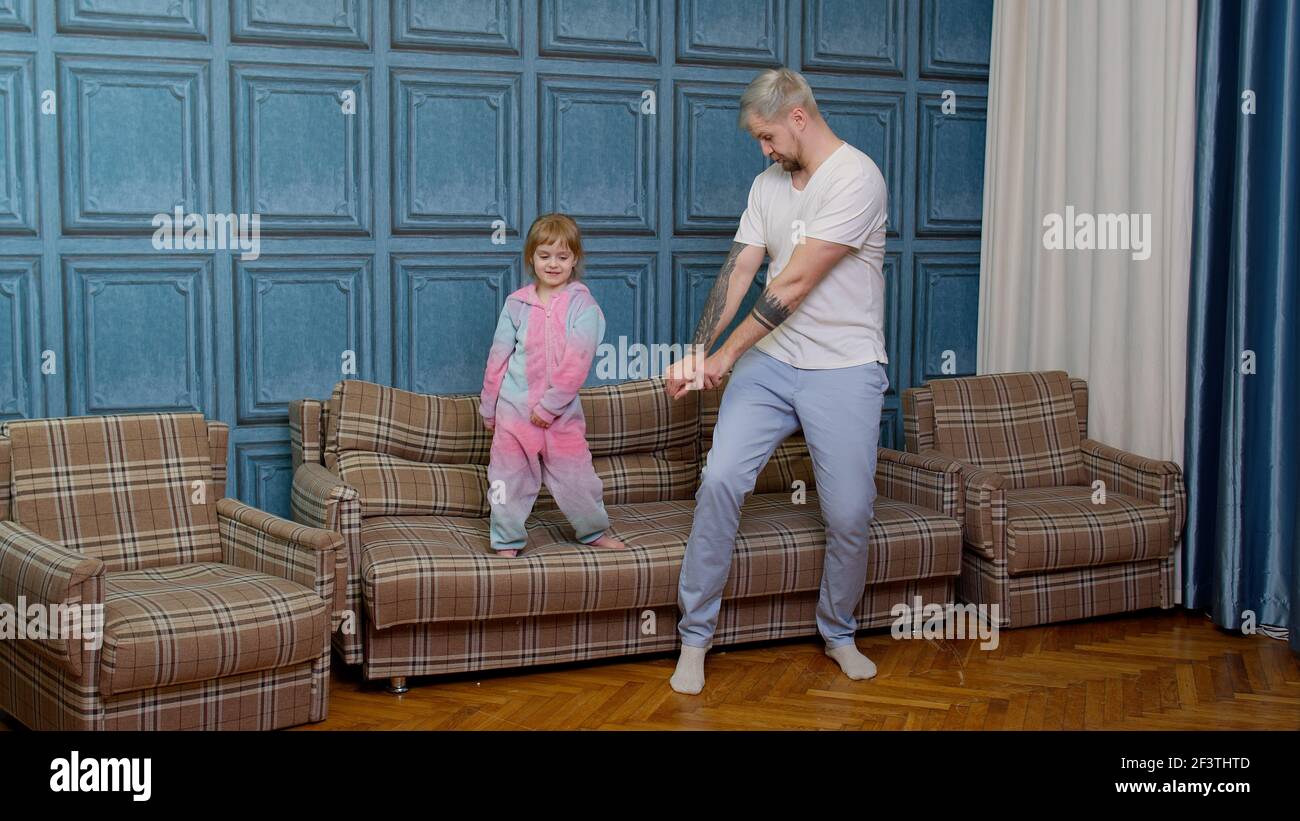 Happy funny family father and child kid daughter dancing, jumping on ...