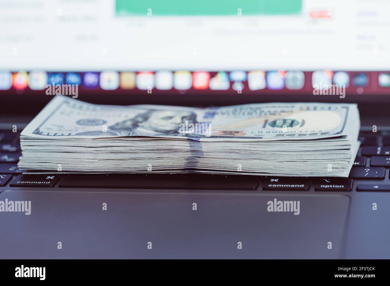 Laptop and US dollar money,Computer notebook and dollar banknotes on a ...