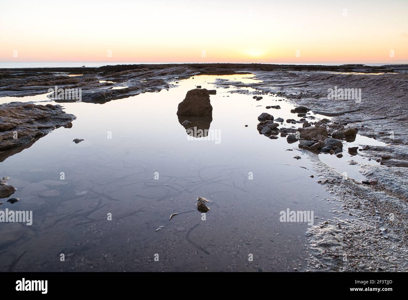 beautiful sunrise on the beach with rocks, located in Alicante, Spain ...