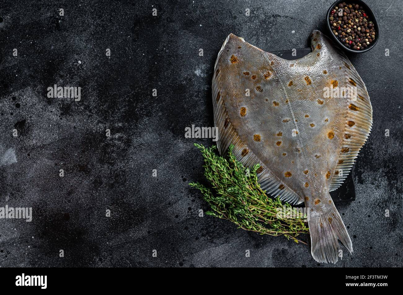 Raw flounder flatfish fish on marble board with thyme. Black background ...