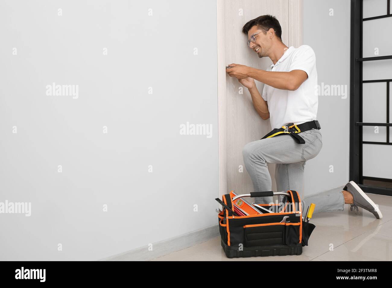 Construction worker repairing door indoors Stock Photo - Alamy
