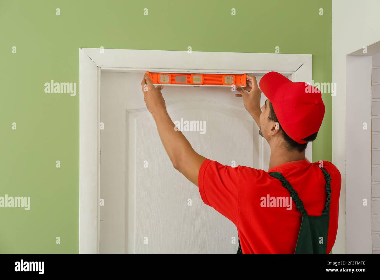 Worker with ruler level taking measurements indoors Stock Photo - Alamy